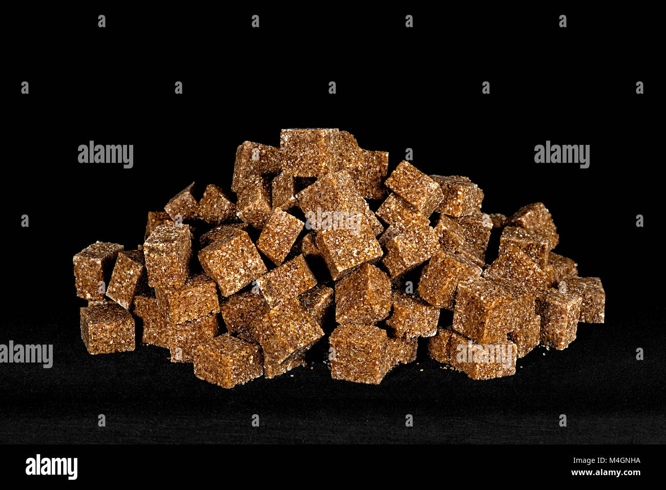 brown sugar cubes piled on a black background Stock Photo - Alamy