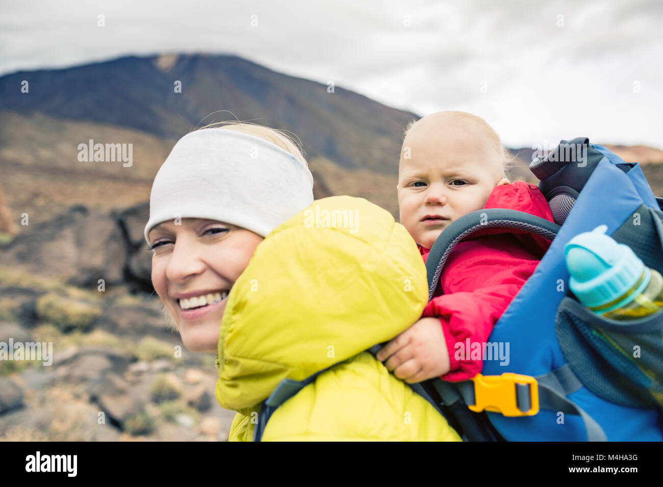 Happy mother with little boy travelling in backpack. Hiking adventure ...