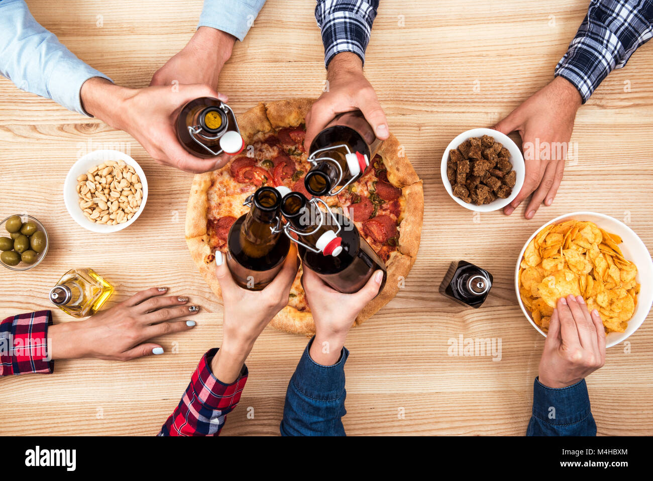 friends clinking bottles of beer Stock Photo - Alamy