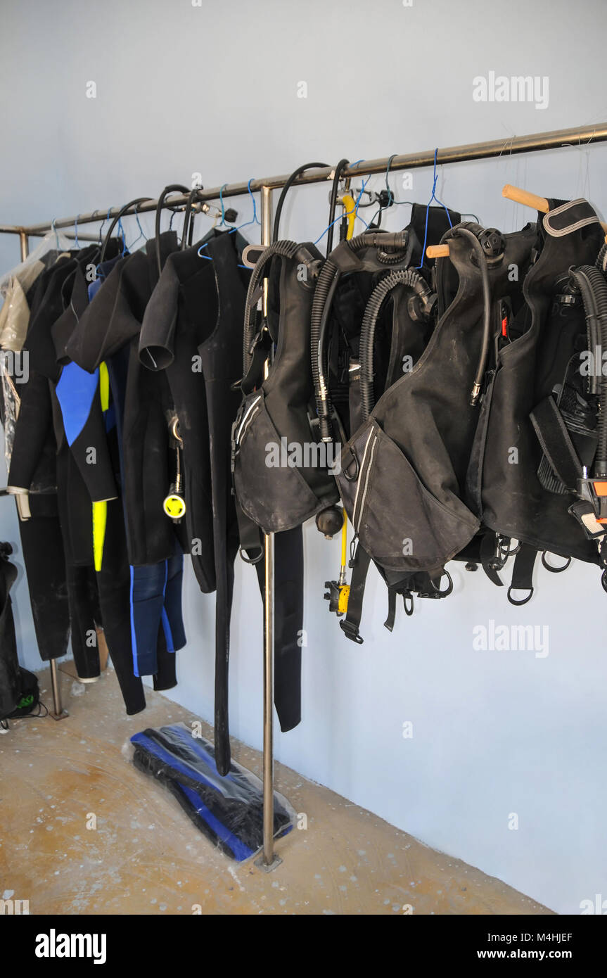Diving gear hanging on racks including flippers, buoyancy compensation ...
