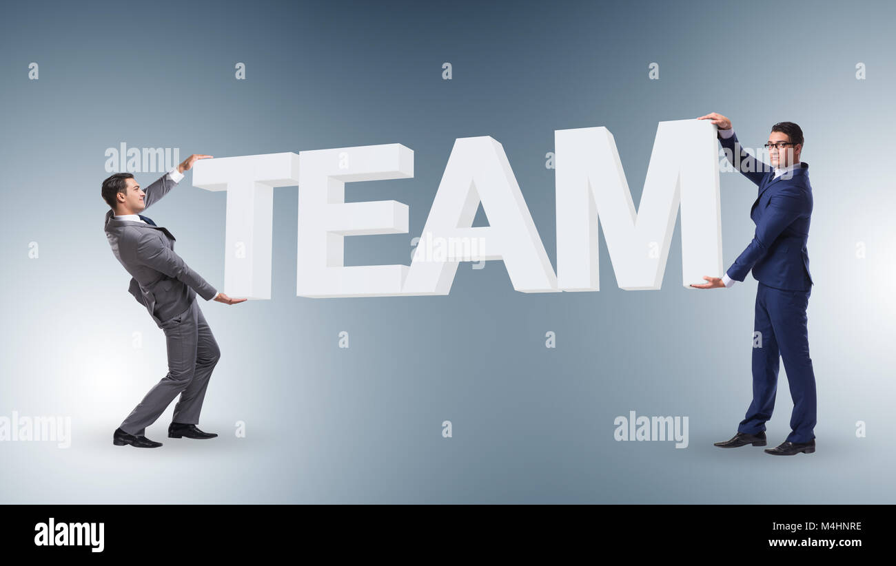 Businessmen holding word team in teamwork concept Stock Photo - Alamy
