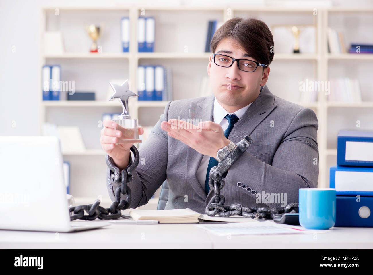 Businessman tied with chains to his work Stock Photo - Alamy