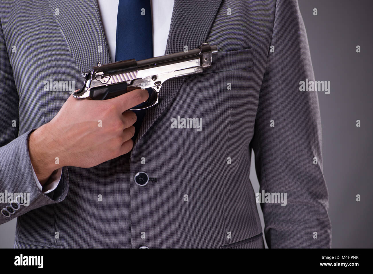 Businessman pulling the gun out of pocket Stock Photo - Alamy