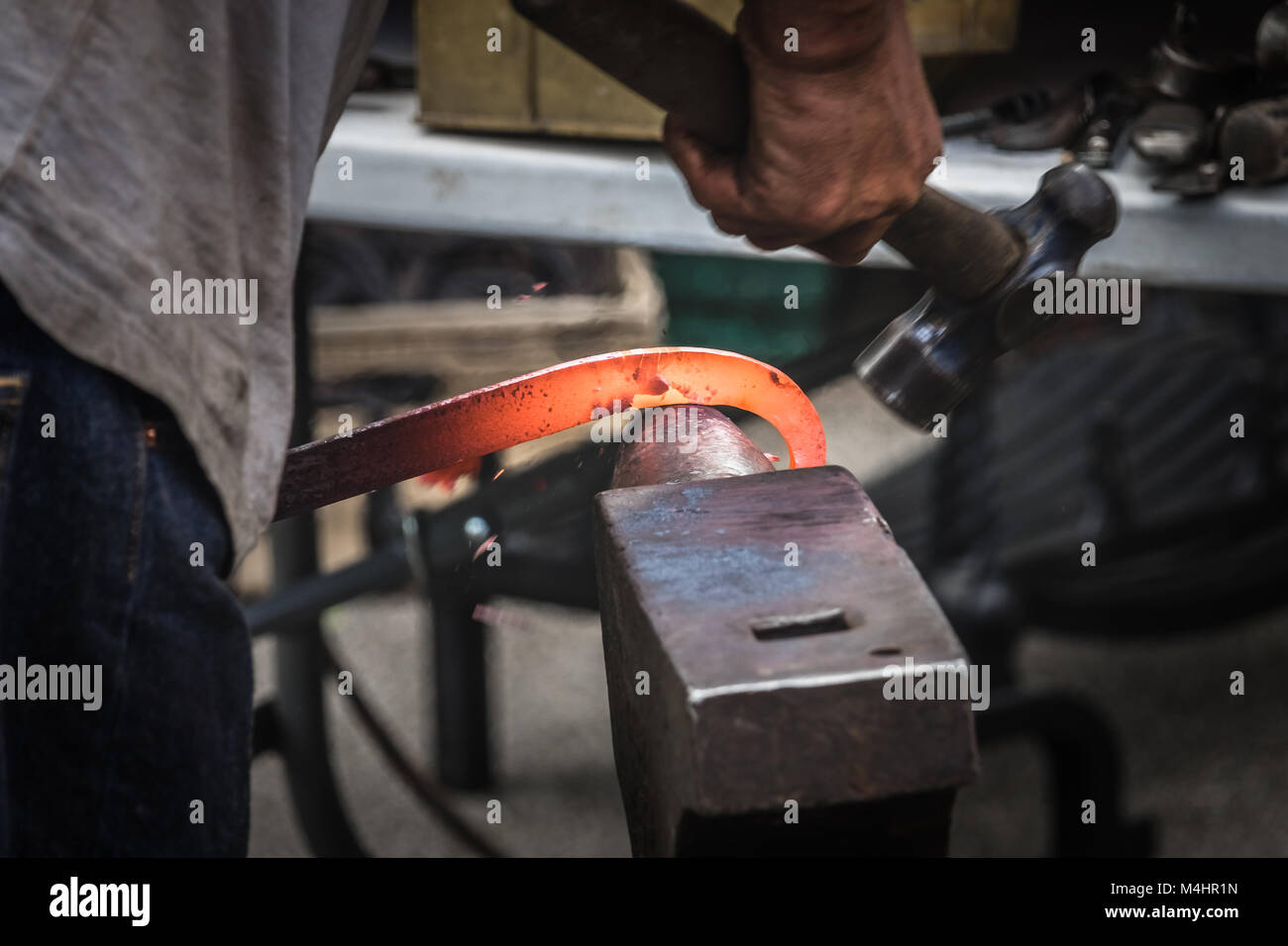 A blacksmith hammering hot iron Stock Photo - Alamy