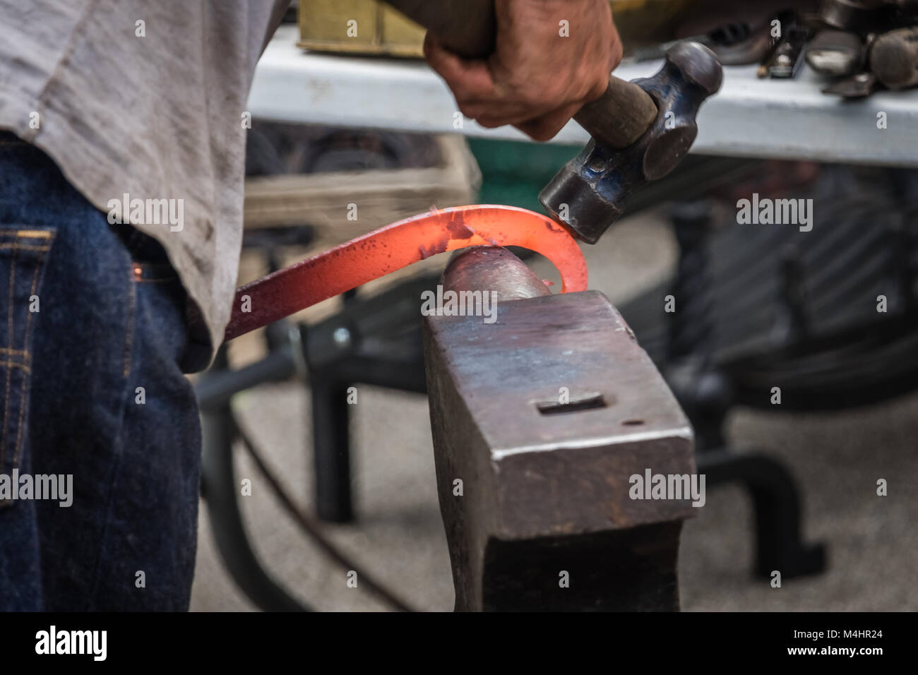 A blacksmith hammering hot iron Stock Photo - Alamy