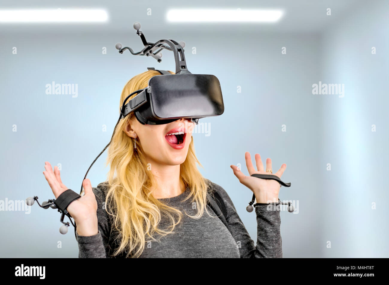 Beautiful woman shocked during VR experience in room. She wearing ...