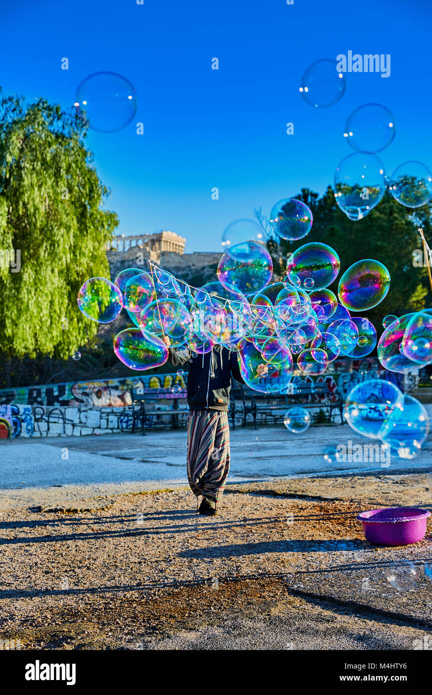 Man produces soap color bubbles with Acropolis of Athens in the ...