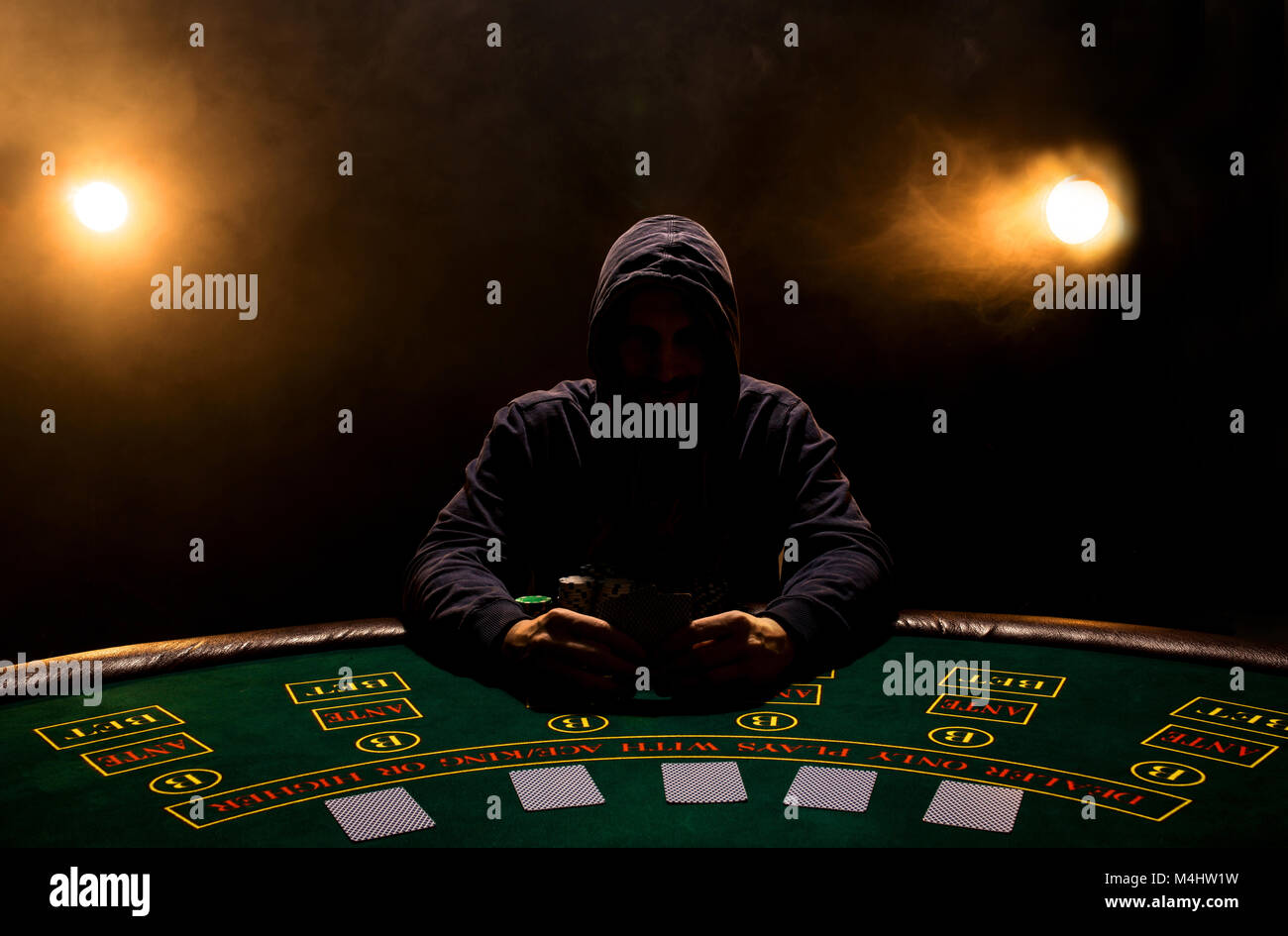 Portrait of a professional poker player sitting at poker table. A man ...