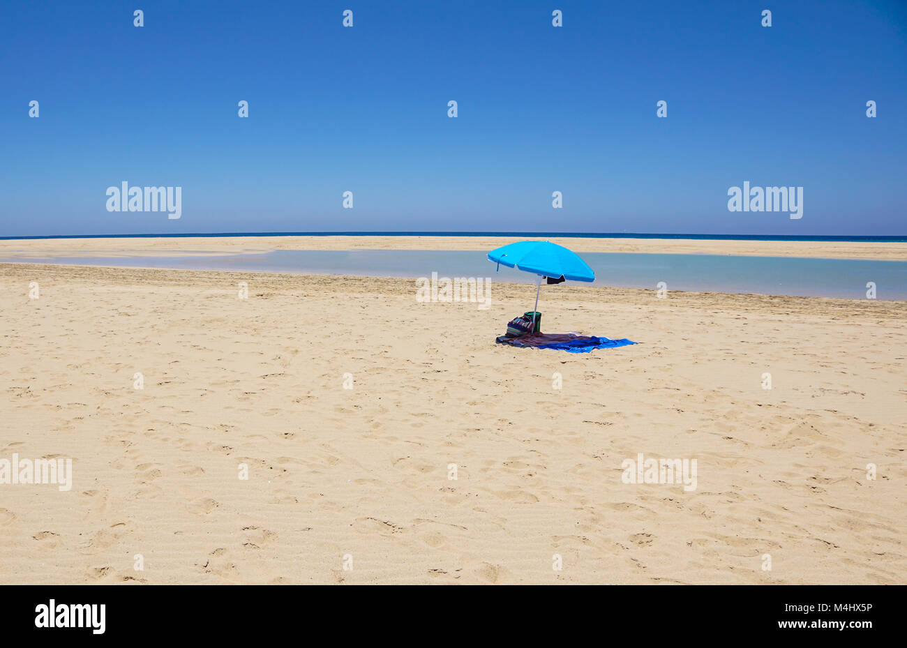 Desert beach with sun shades, tranquil sea, blue sky, clouds . Summer ...