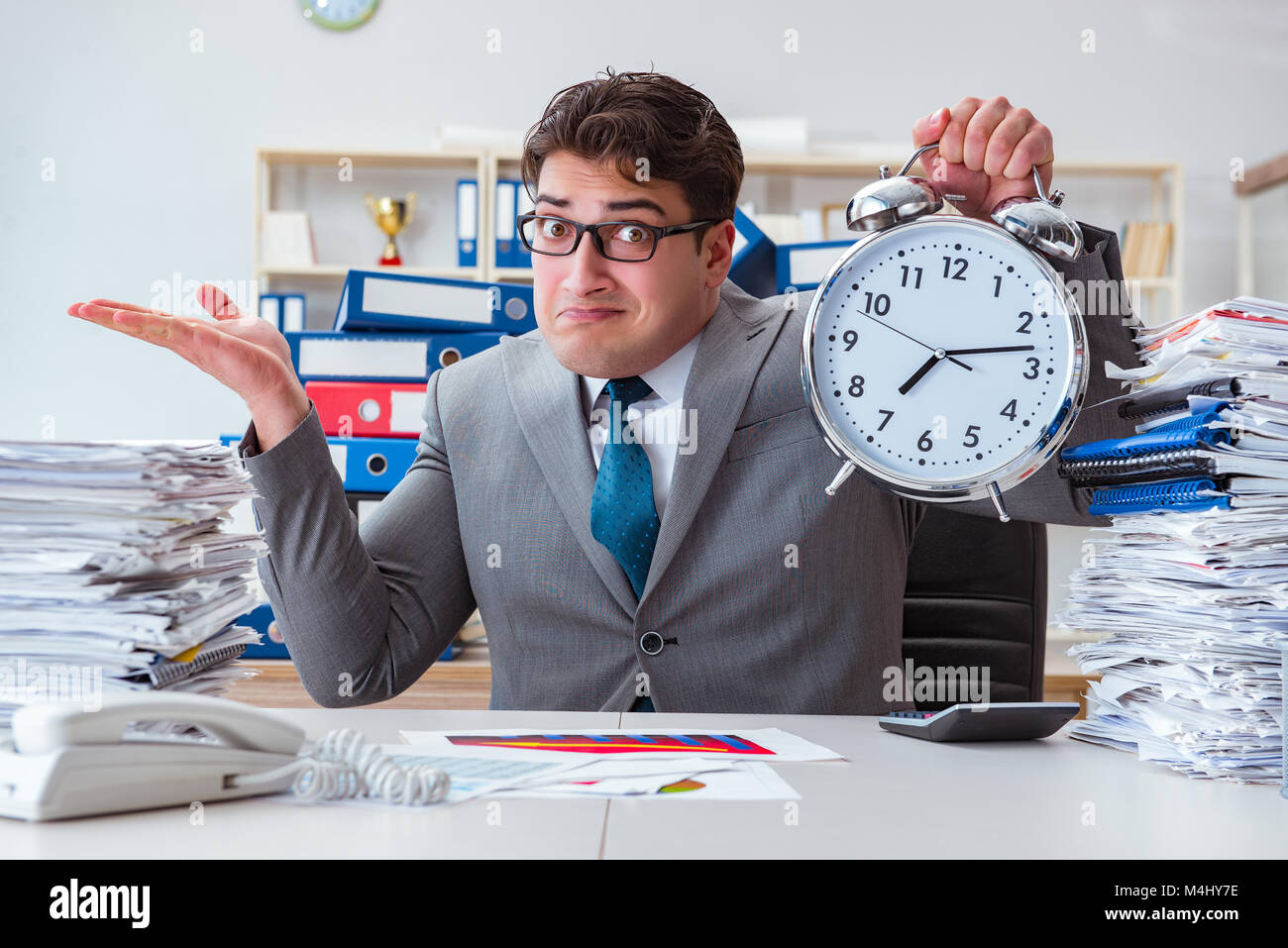 Businessman missing deadlines due to excessive work Stock Photo - Alamy