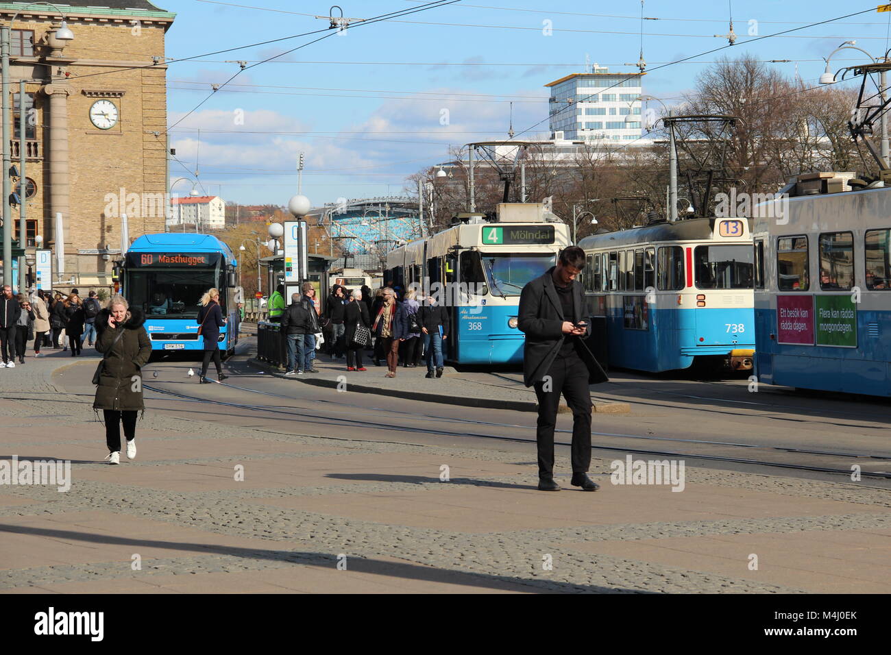 Passengers, trams and a bus on Drottningtorget in Gothenburg in Sweden ...