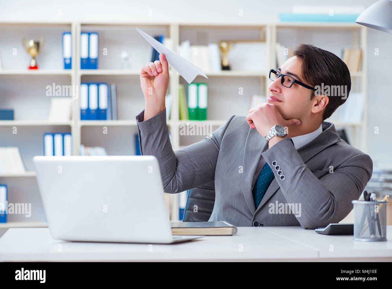 Businessman with paper airplane in office Stock Photo - Alamy