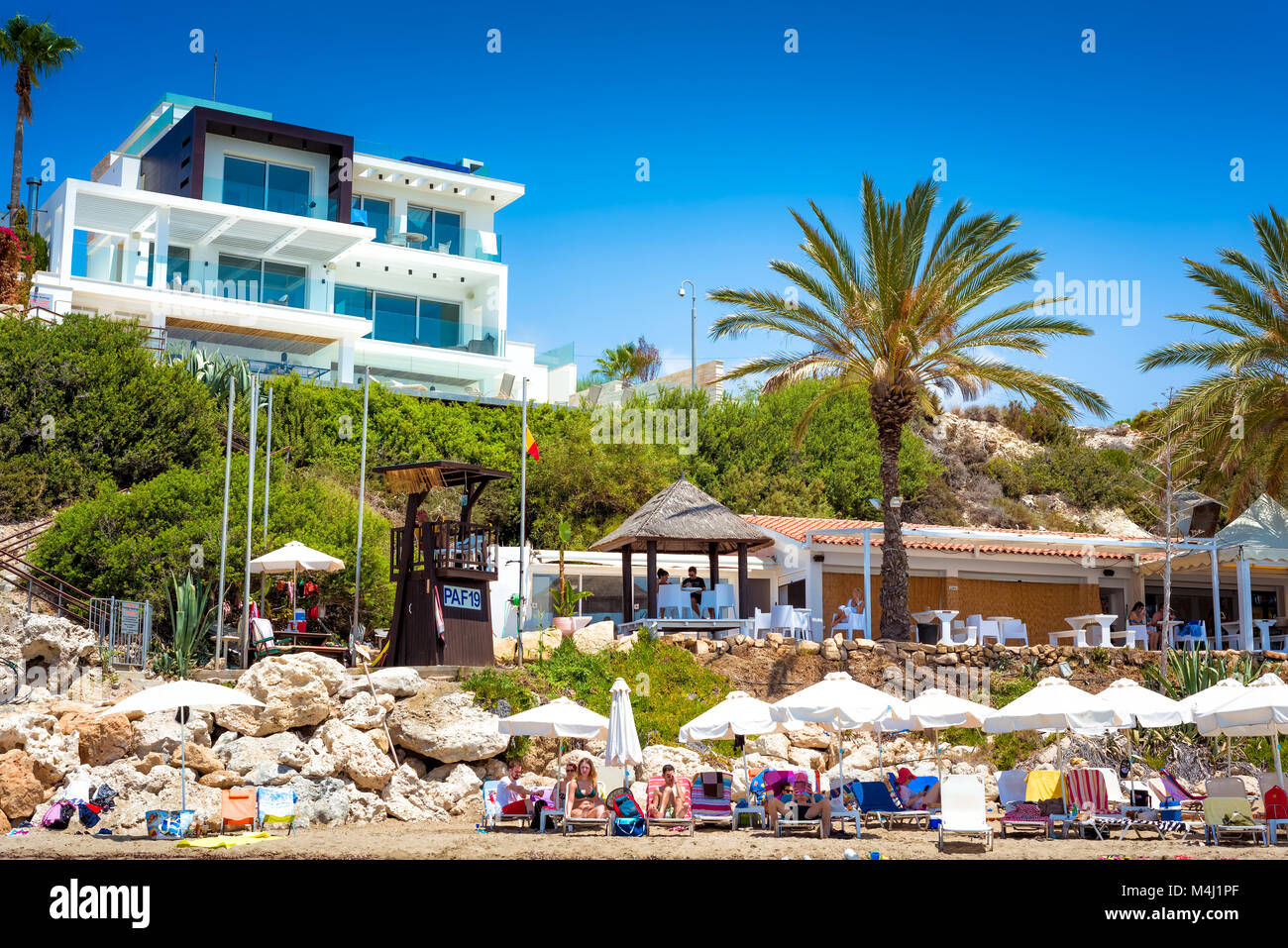 PAPHOS, CYPRUS - JULY 24, 2016: People relaxing at Coral Bay beach ...