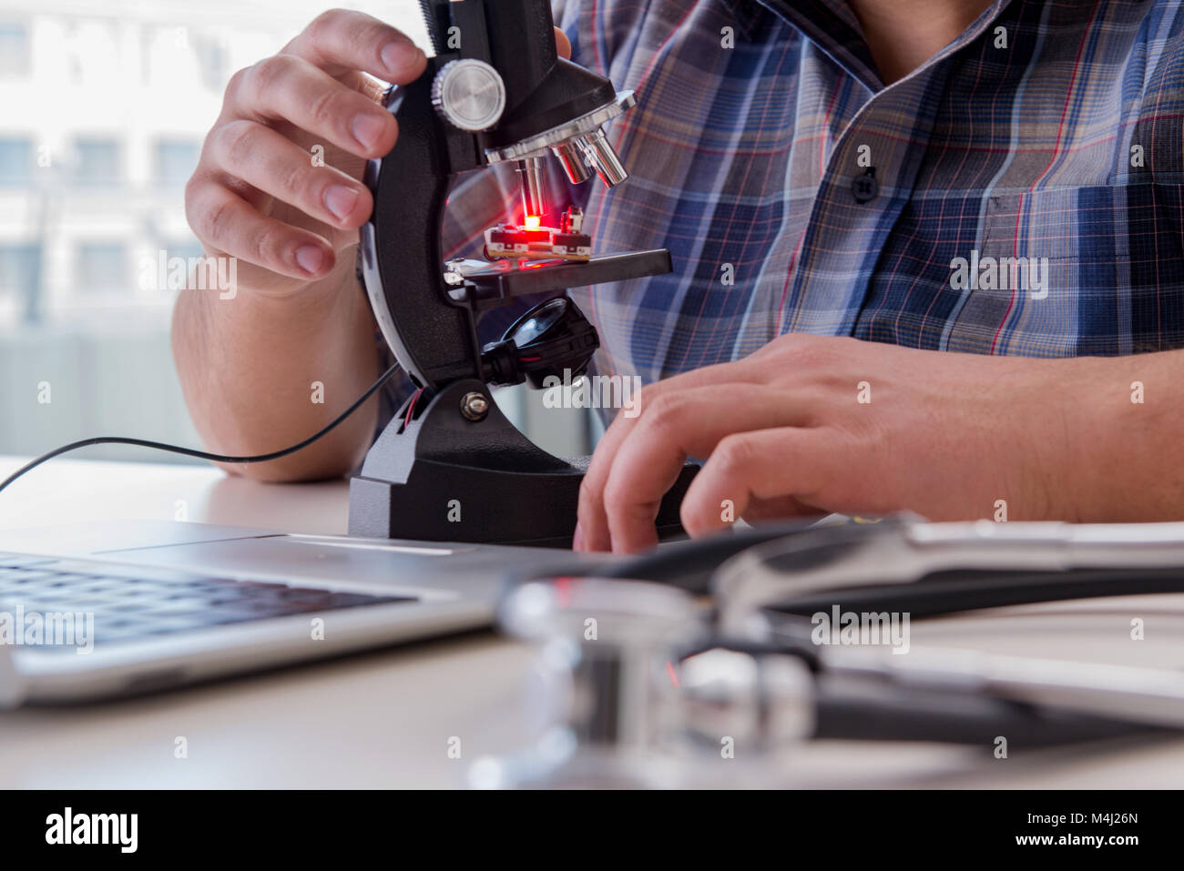 High precision engineering with man working with microscope Stock Photo ...