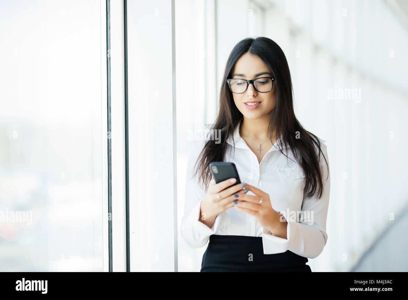 Beautiful women use the phone at the window Stock Photo - Alamy