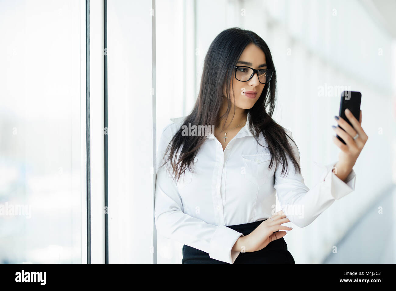 Beautiful women use the phone at the window Stock Photo - Alamy