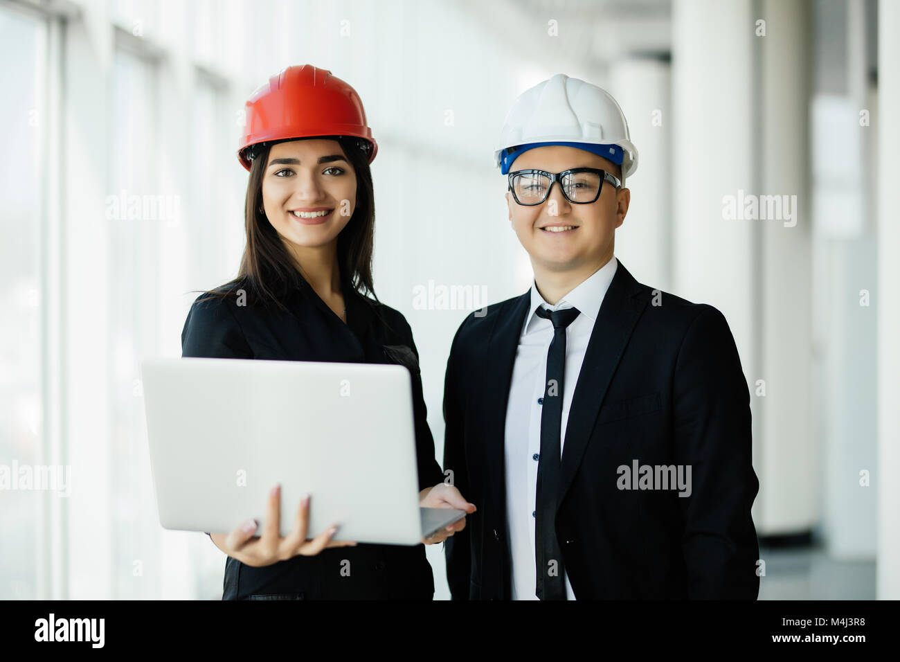 Engineers working on a building site holding a laptop, architect man ...