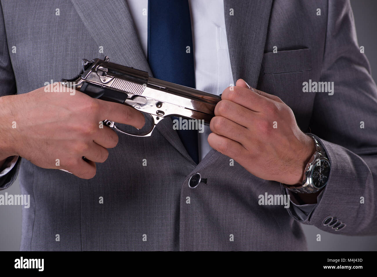 Businessman pulling the gun out of pocket Stock Photo - Alamy