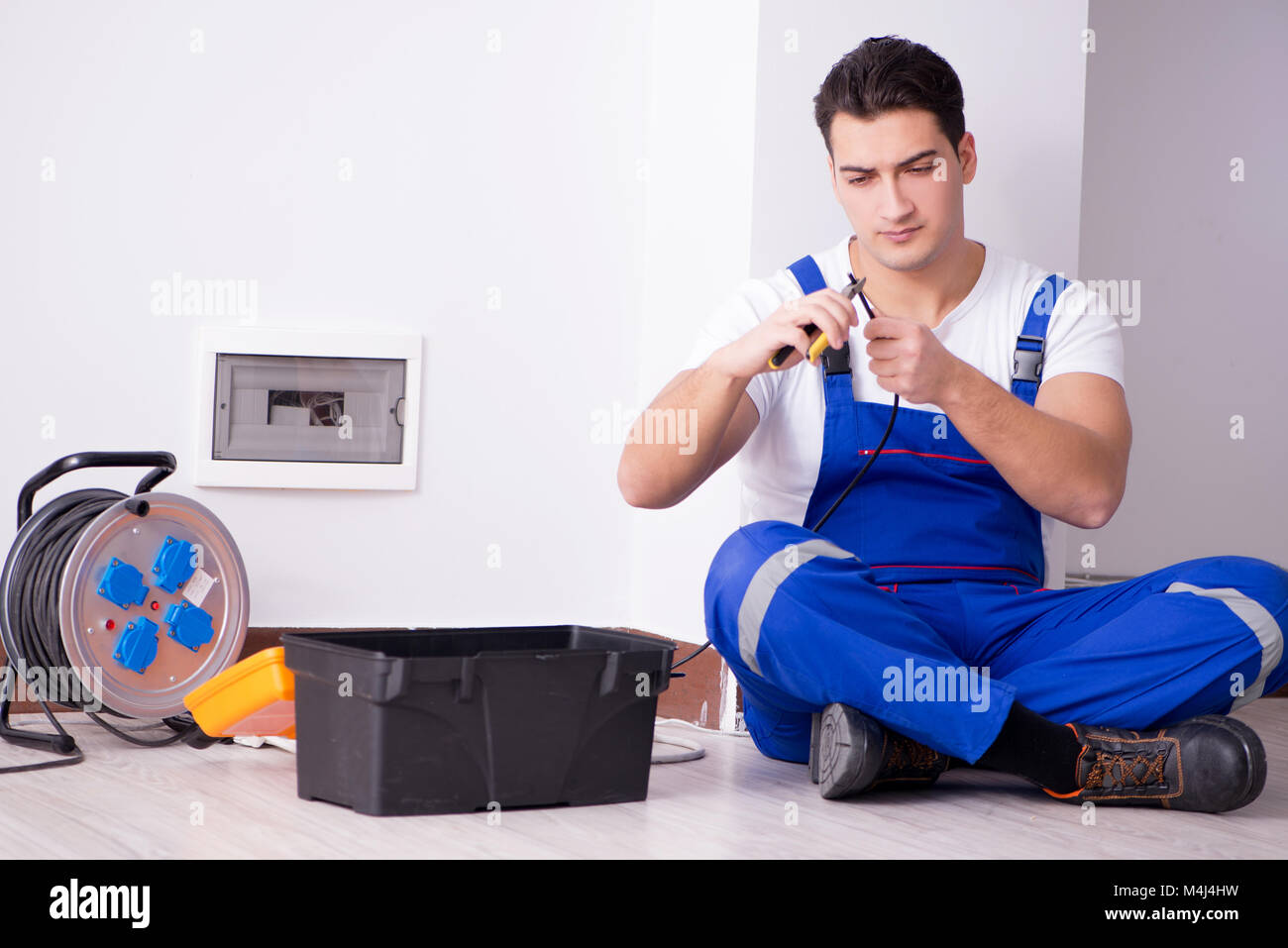 Young electrician working on socket at home Stock Photo - Alamy