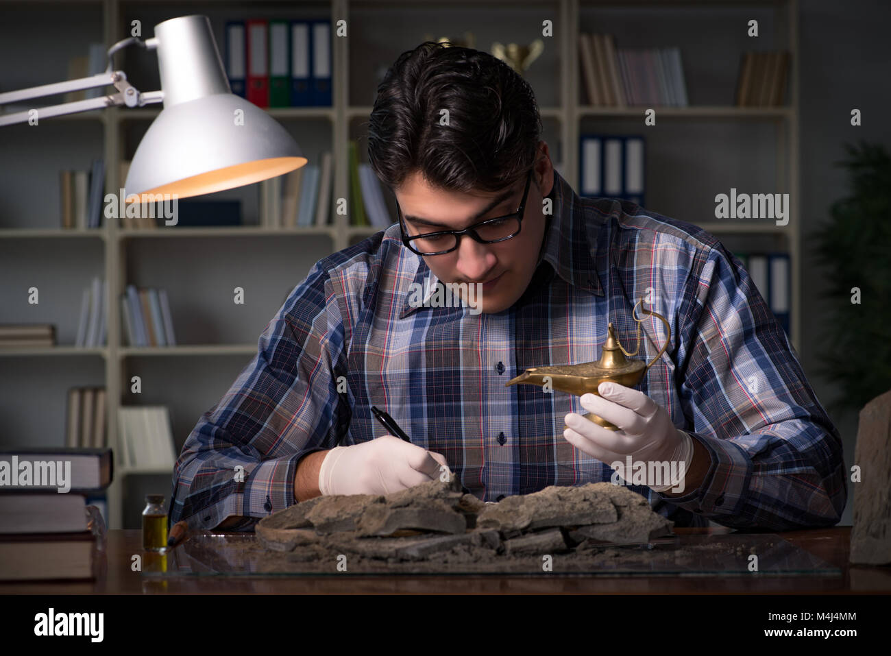Archeologist working late night in office Stock Photo - Alamy