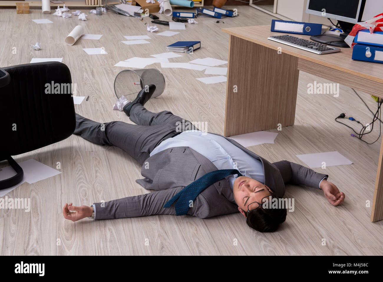 Businessman dead on the office floor Stock Photo - Alamy