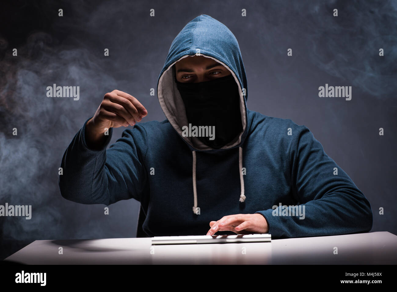 Computer hacker working in dark room Stock Photo - Alamy