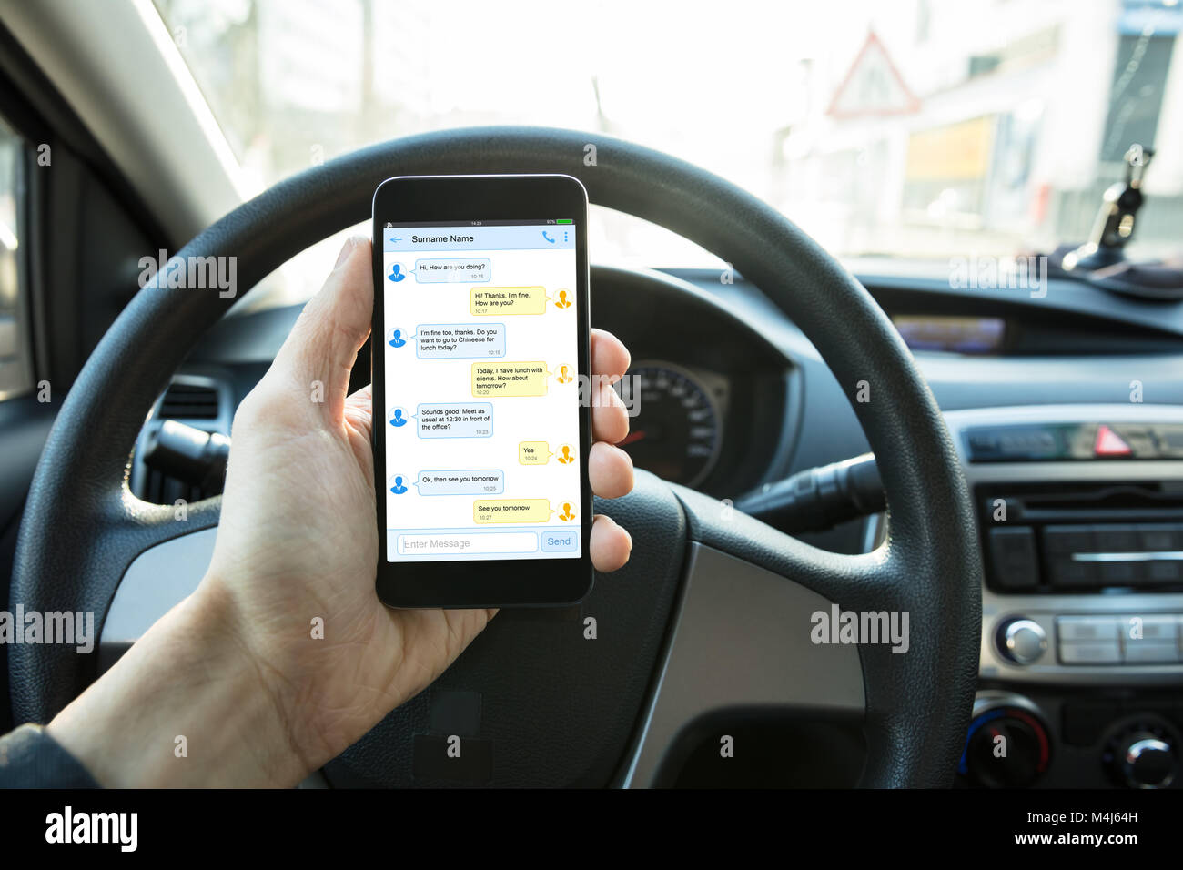 Person Sending Text Message On Mobilephone While Driving The Car Stock ...