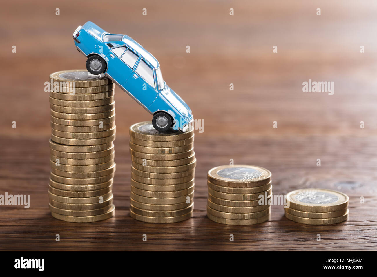 Close-up Of A Car Model Over A Stacked Coin At Wooden Desk Stock Photo ...