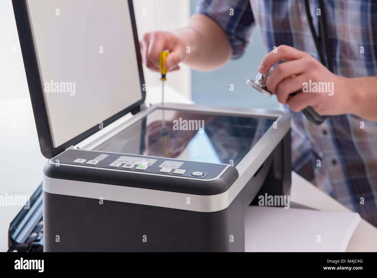 Repairman repairing broken color printer Stock Photo - Alamy