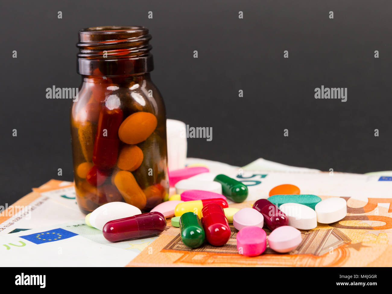 Fifty euro bills and pills or tablets on dark background with copyspace ...