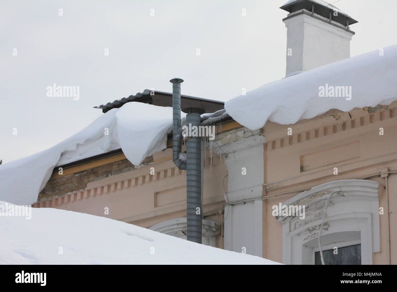 Snow falls hanging down from the roof Stock Photo - Alamy