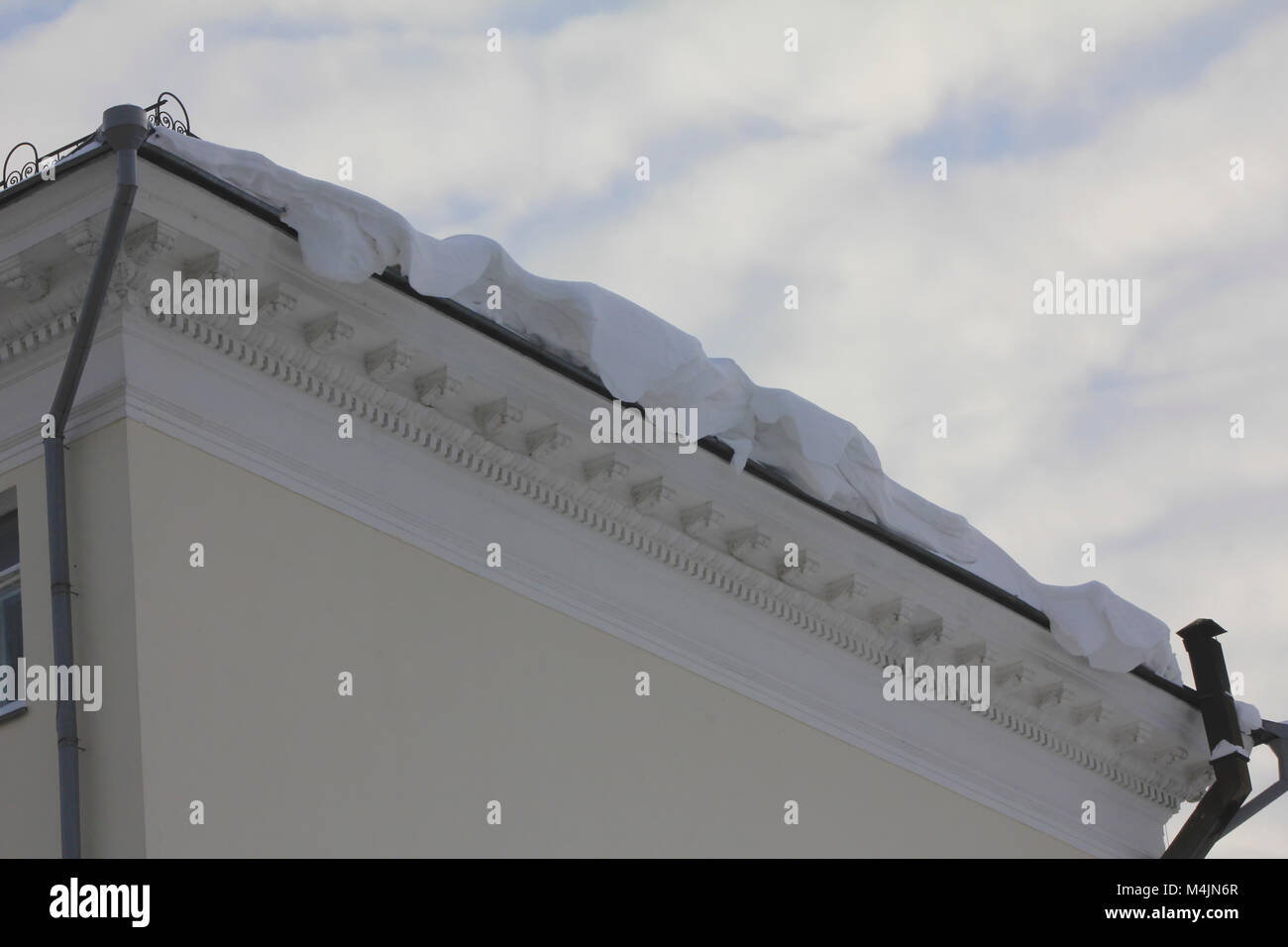 Snow bank hanging down from the roof Stock Photo - Alamy