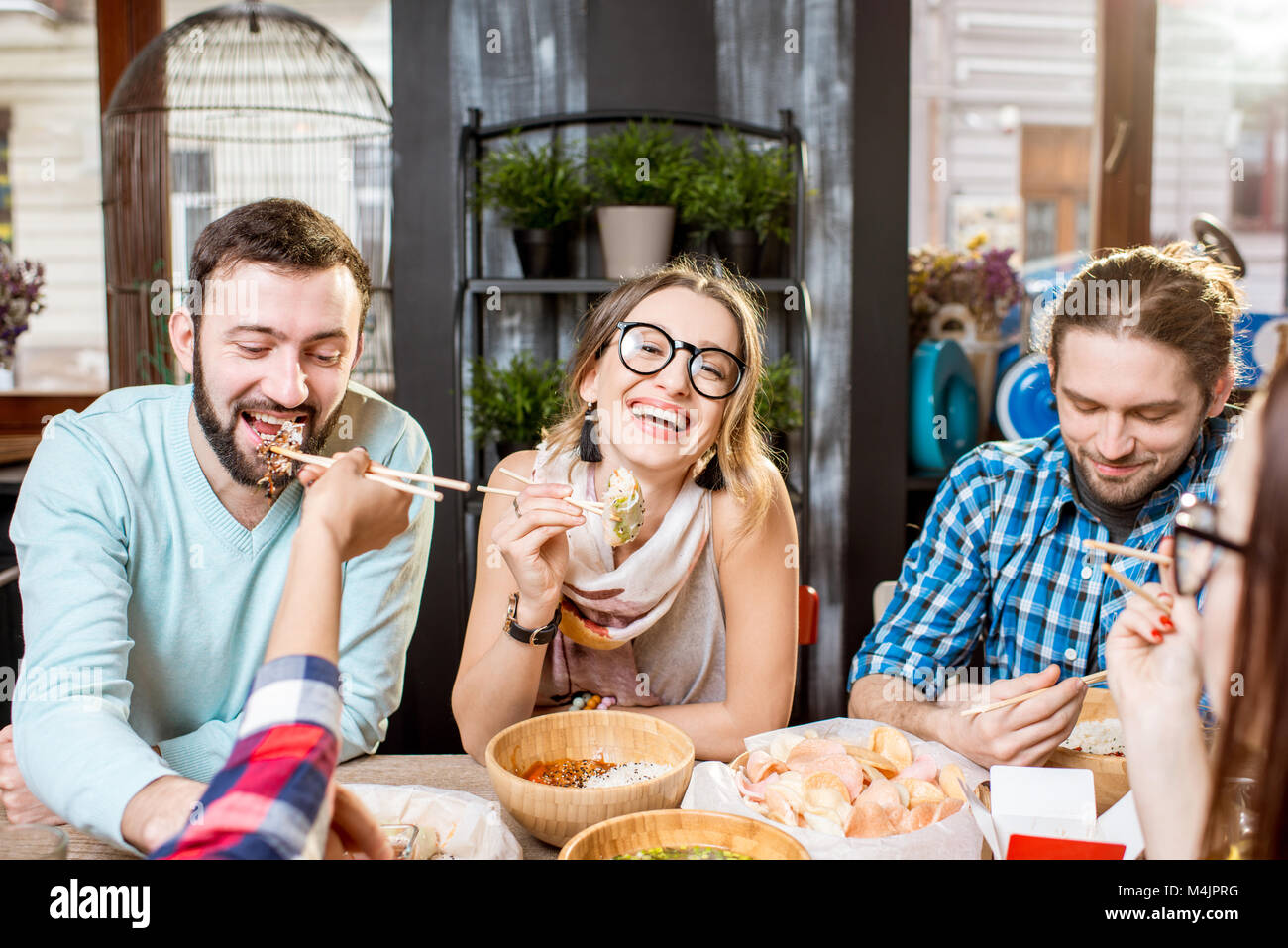 Friends eating asian meals at the restaurant Stock Photo - Alamy