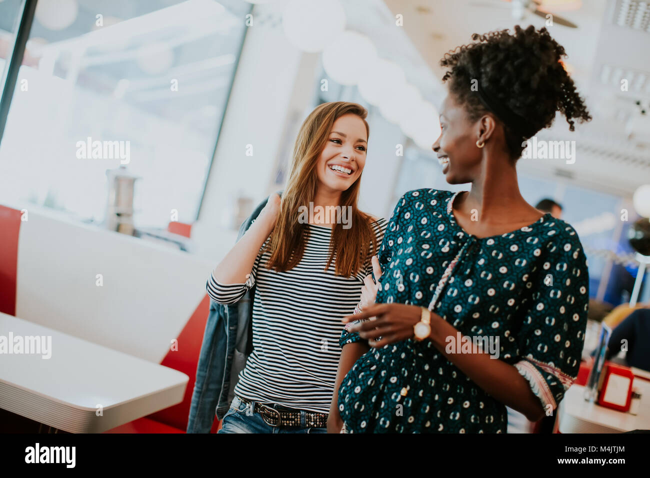 Pretty young multiethnic women having fun in the diner Stock Photo - Alamy