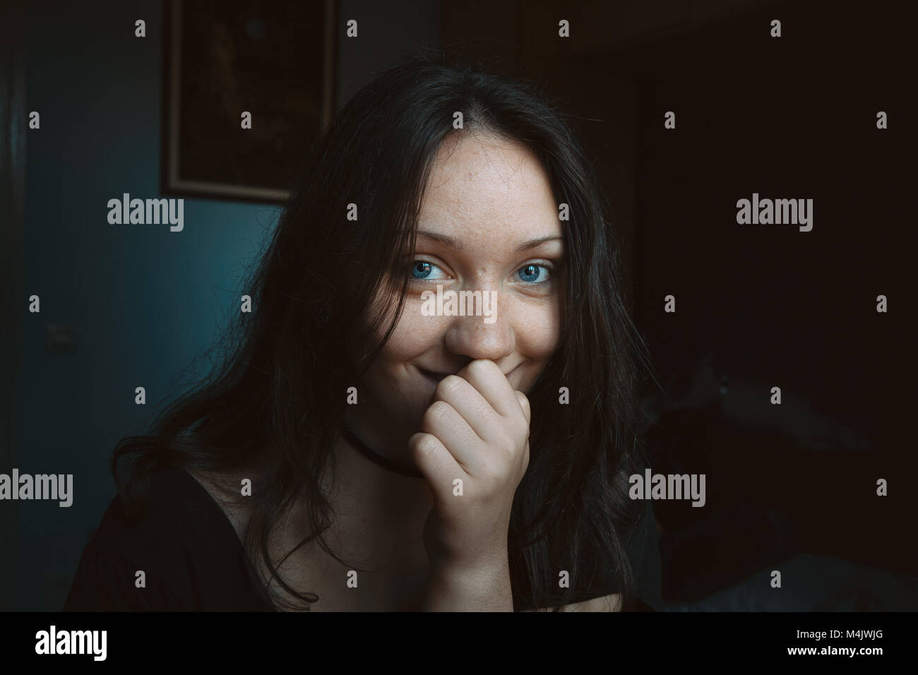 girl smiling shyly with her hand on her lips Stock Photo - Alamy