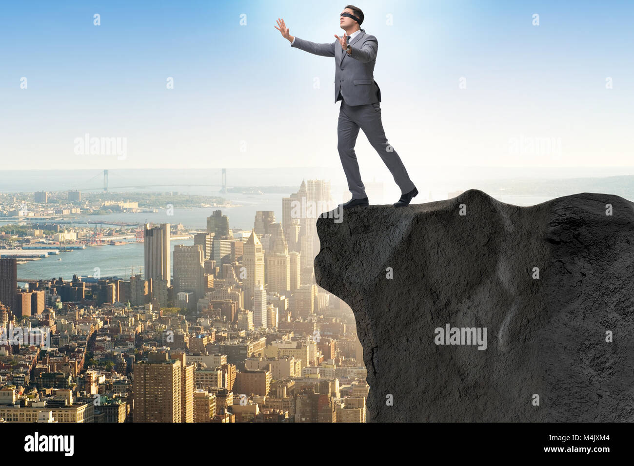 Blindfold businessman standing on tip of cliff Stock Photo - Alamy