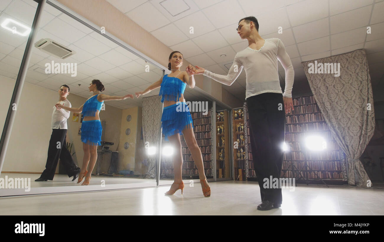 Young attractive man and woman dancing Latin American dance in costumes ...