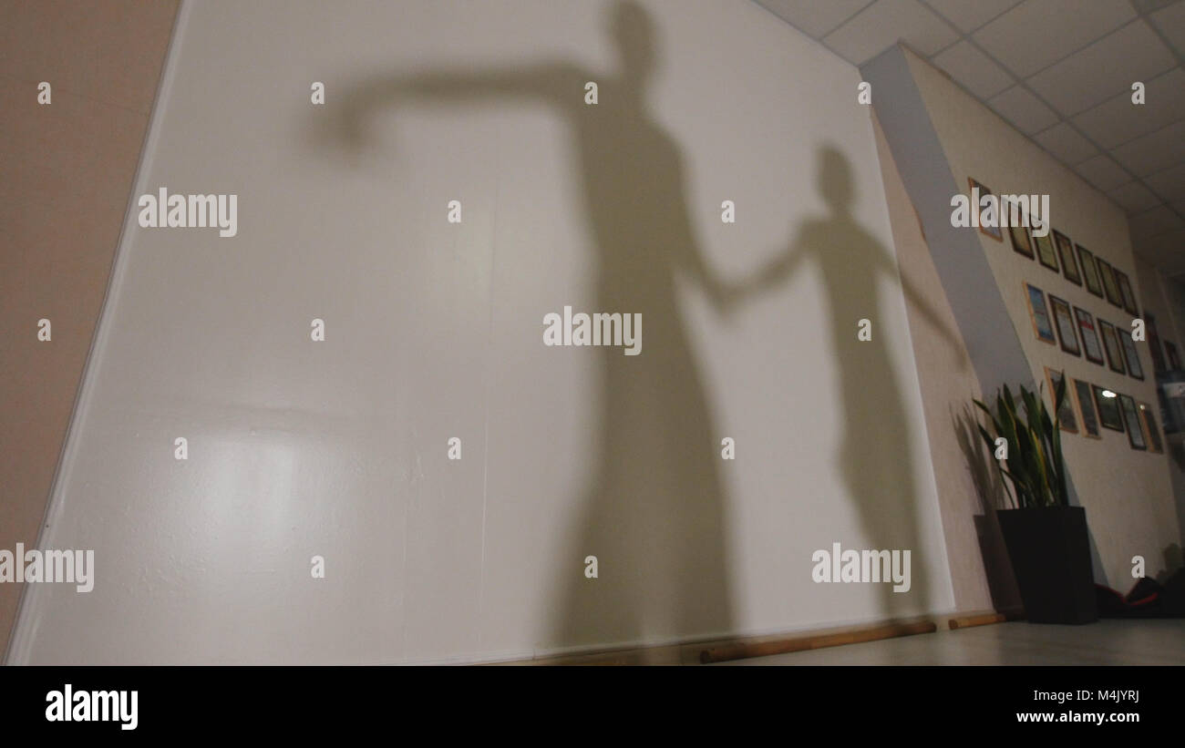 Shadow of man and woman dancing and rehearsing Latin American dance in ...