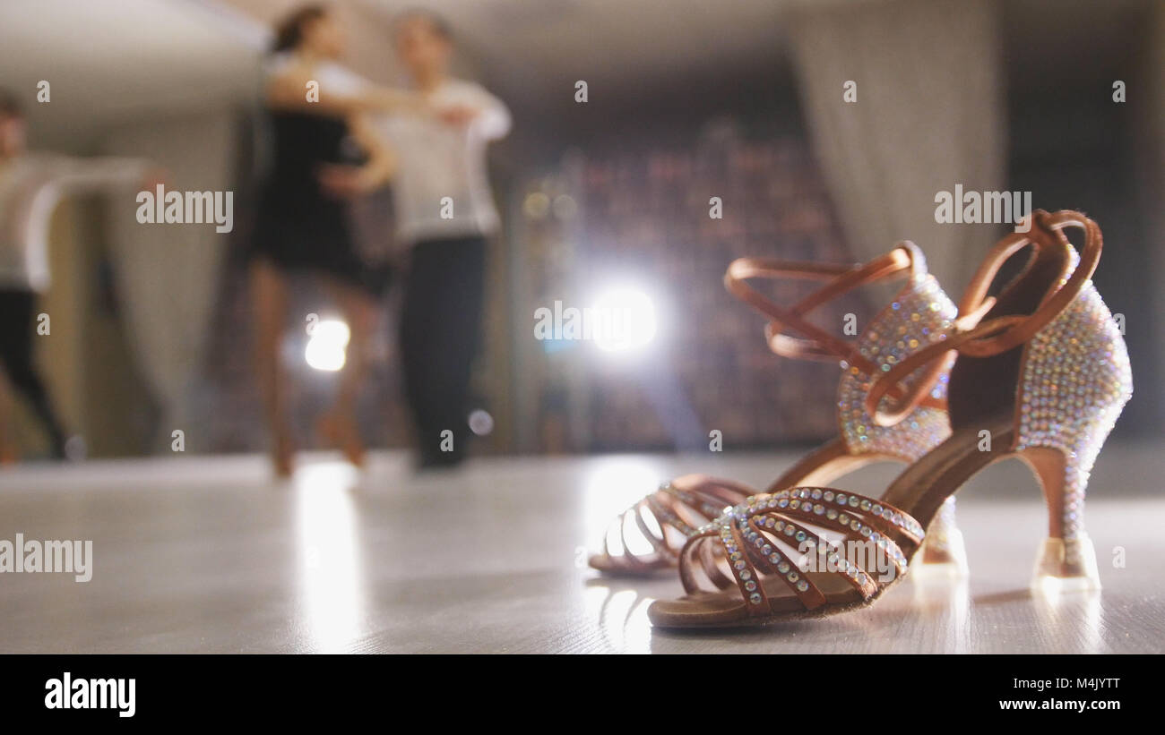 Blurred professional man and woman dancing Latin dance in costumes in the Studio, ballroom shoes ...