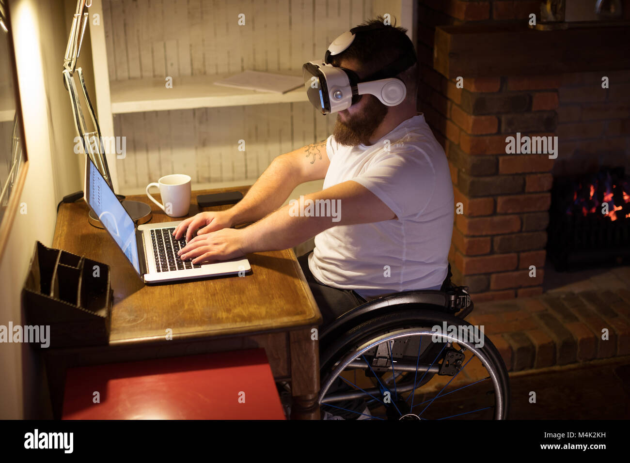 Disabled man in virtual reality headset using laptop Stock Photo - Alamy