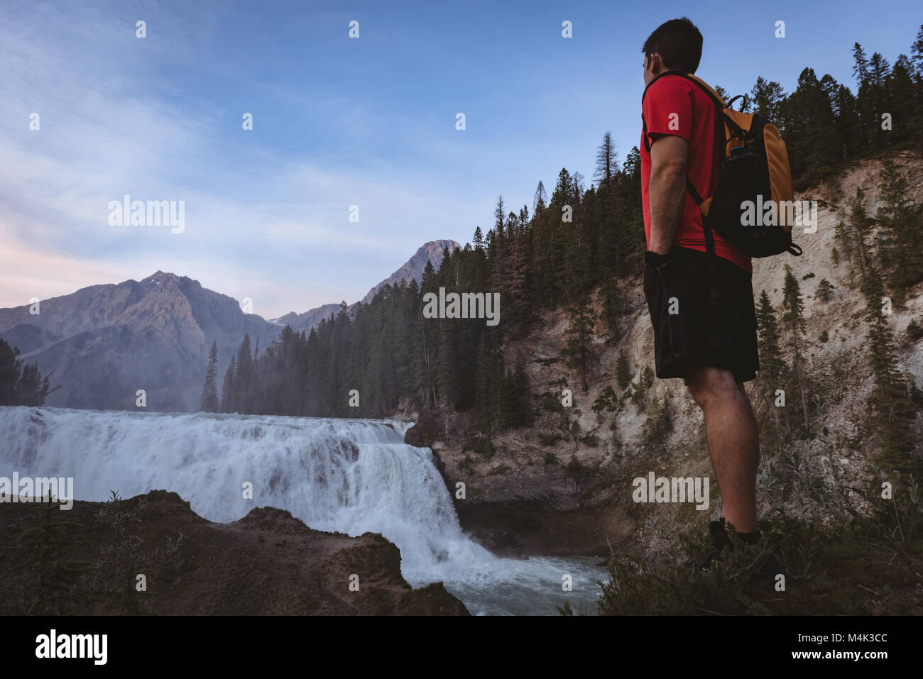 Man standing near waterfall Stock Photo - Alamy