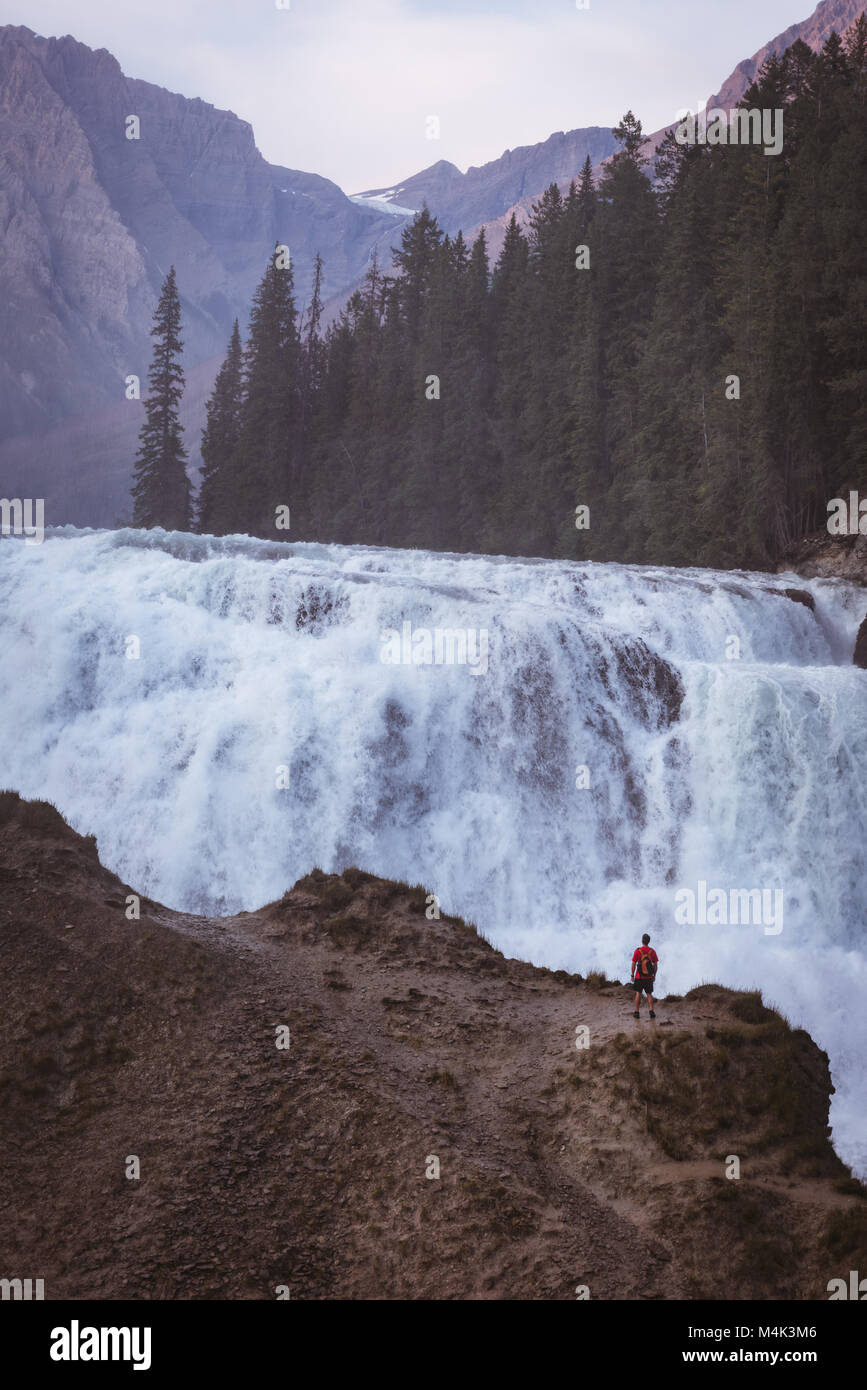 Man looking at waterfall Stock Photo - Alamy