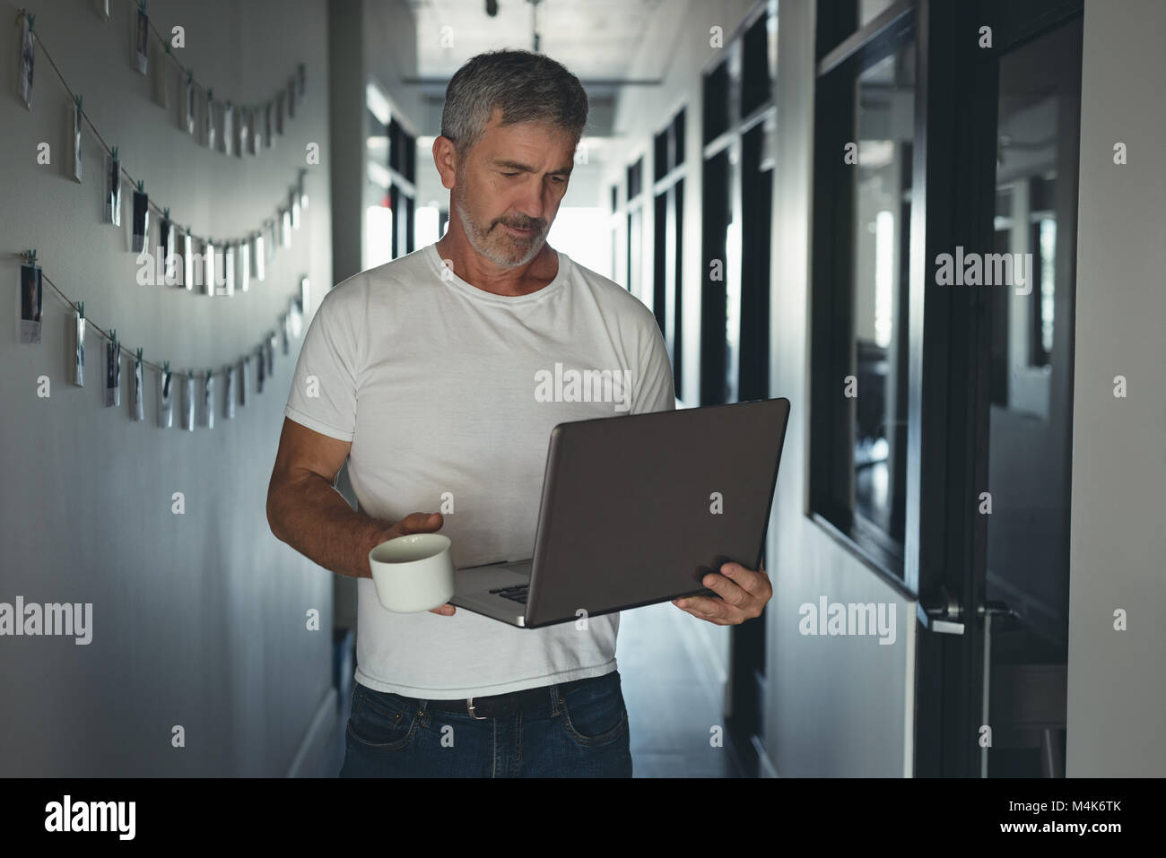 Businessman walking with laptop Stock Photo - Alamy