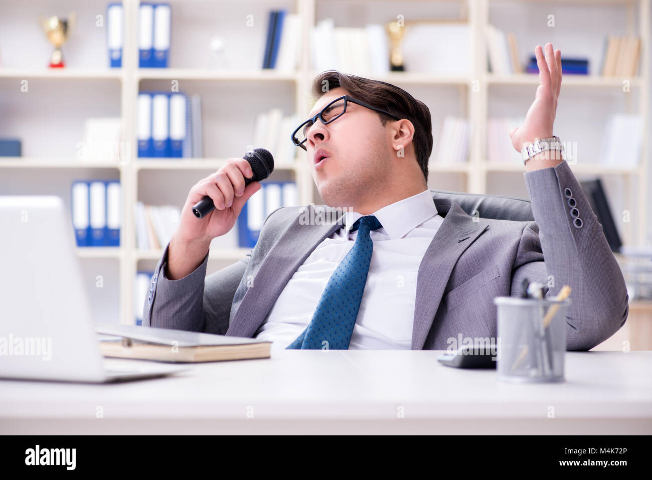 Businessman singing in the office Stock Photo - Alamy