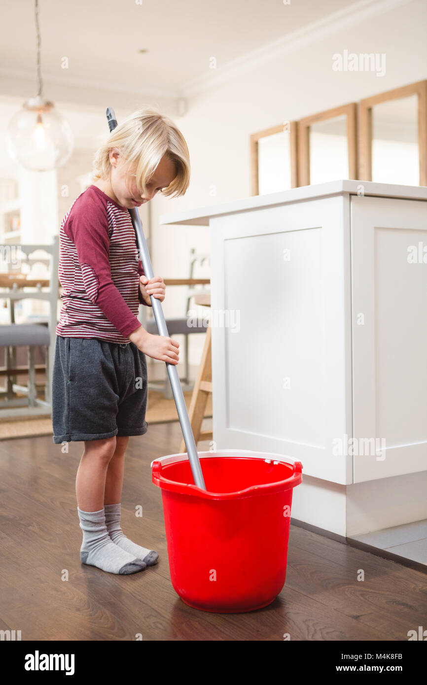 Boy holding floor mop with bucket Stock Photo - Alamy