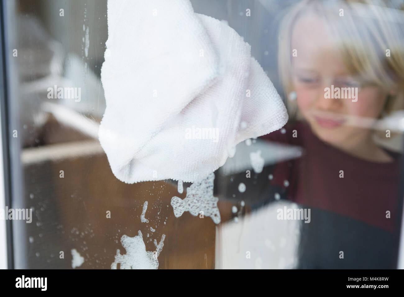Boy cleaning window with rag cloth Stock Photo - Alamy