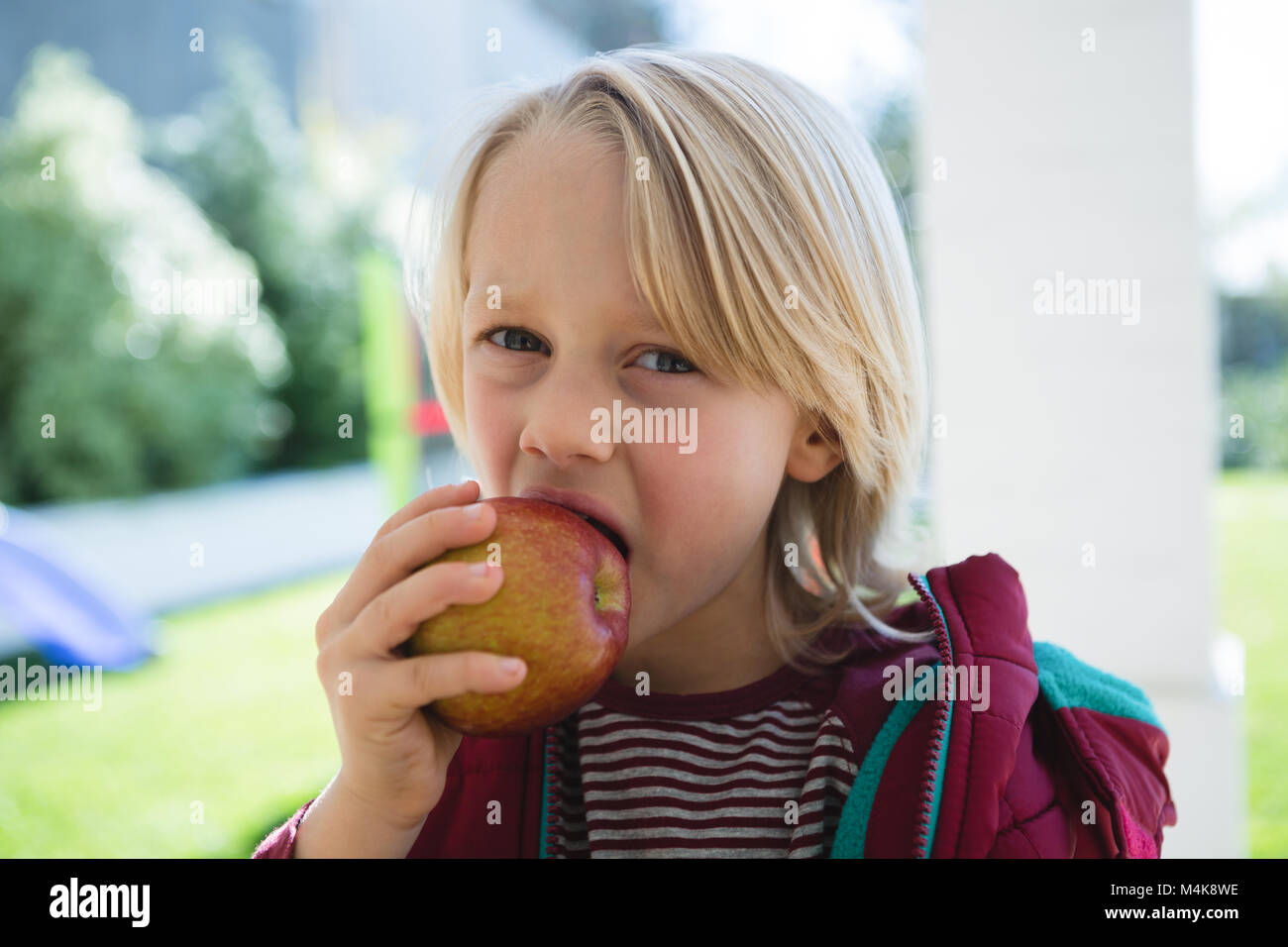 Boy eating apple in the porch Stock Photo - Alamy