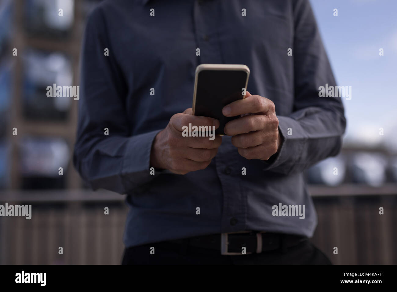 Businessman using mobile phone in hotel premises Stock Photo - Alamy