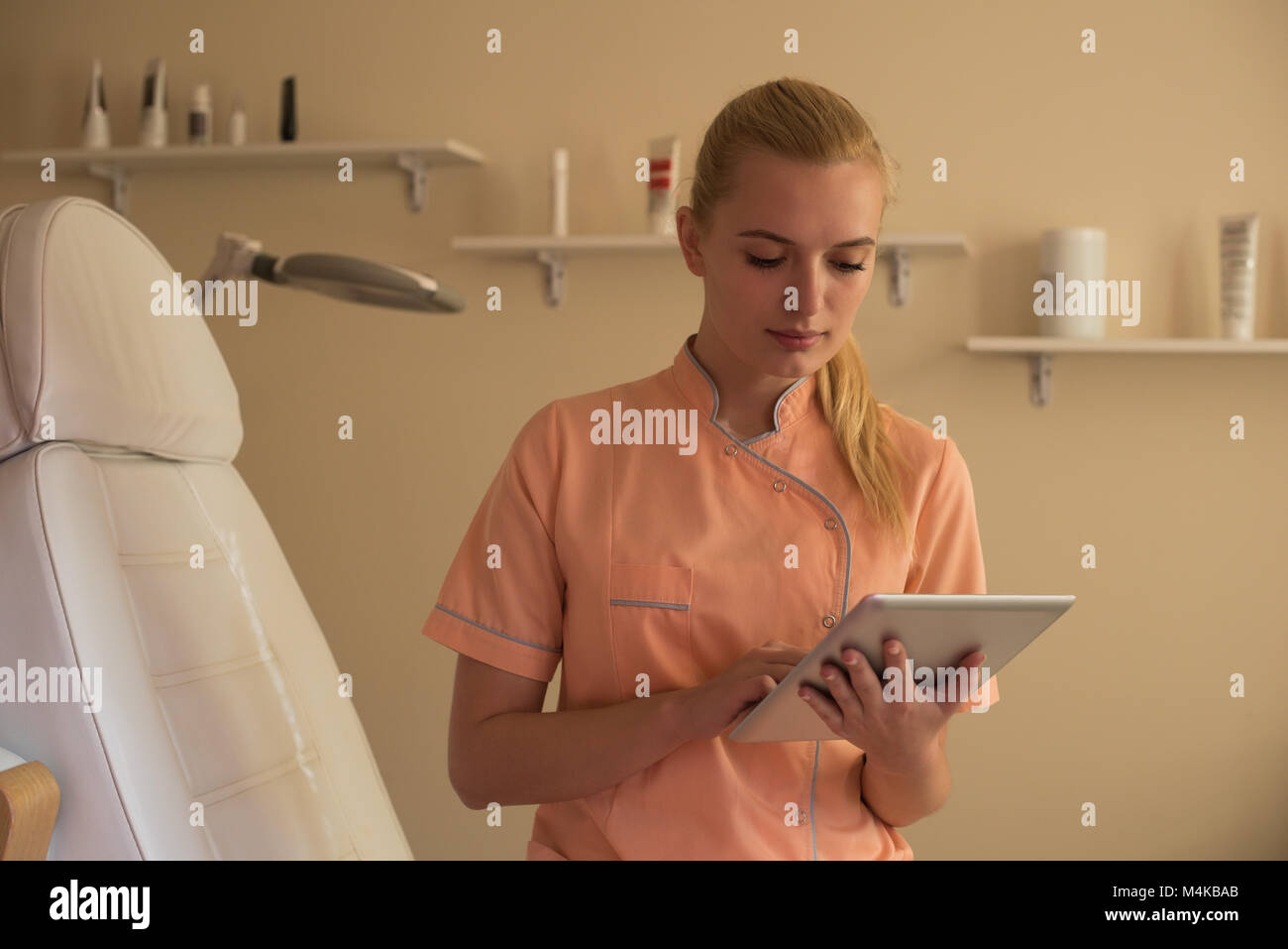 Female beautician using digital tablet in parlour Stock Photo - Alamy