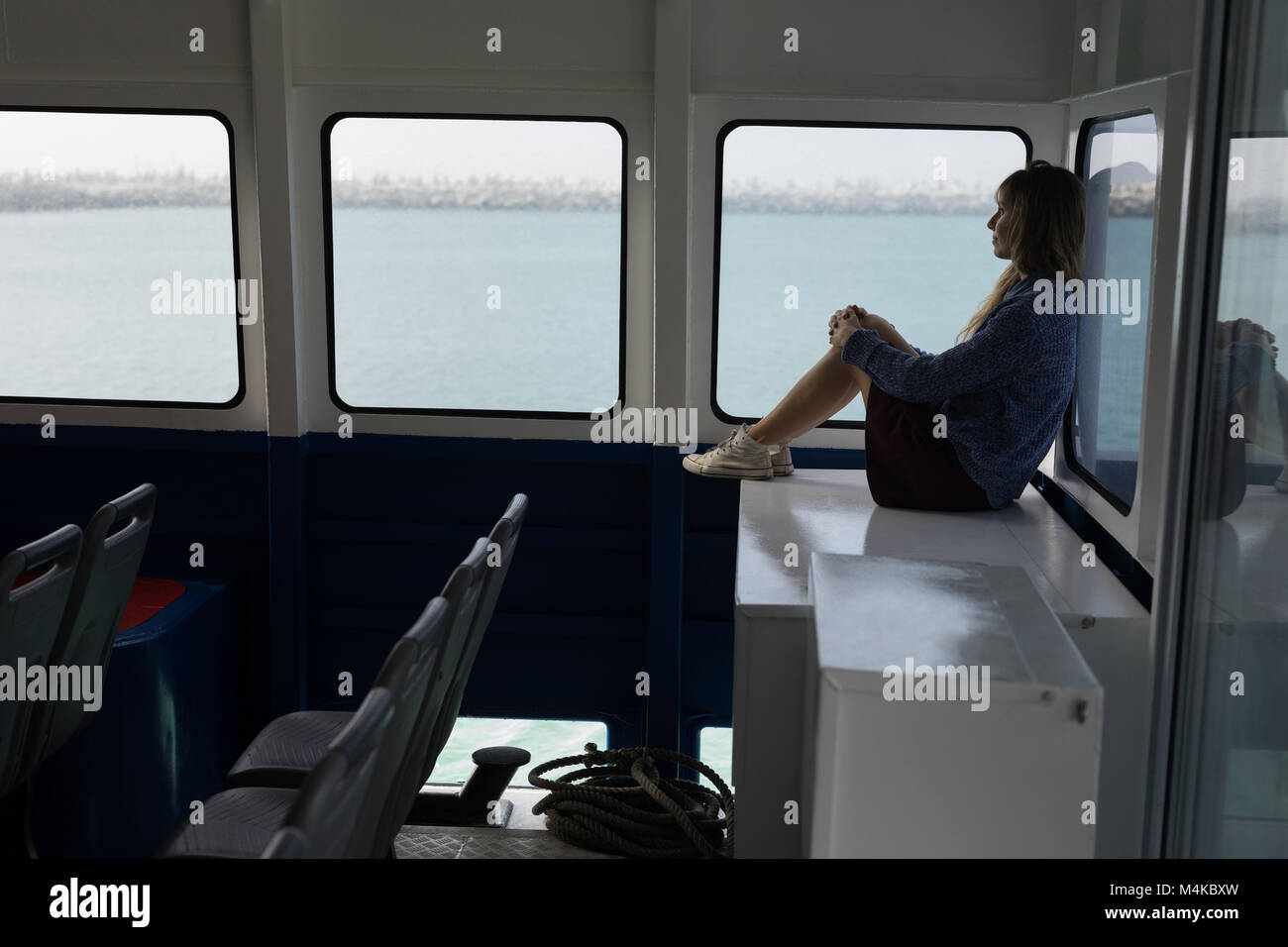 Woman sitting near window in cruise ship Stock Photo - Alamy